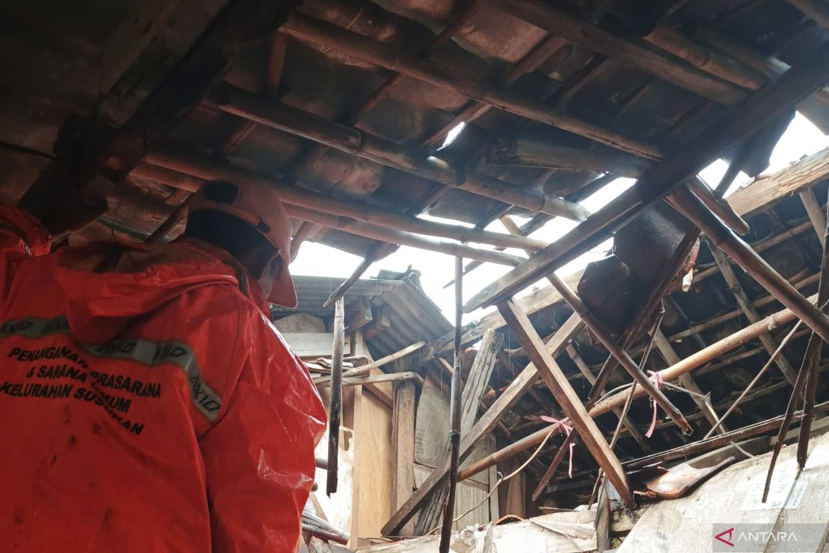 Petugas evakuasi puing atap rumah warga yang ambruk di Ciracas Jaktim ...
